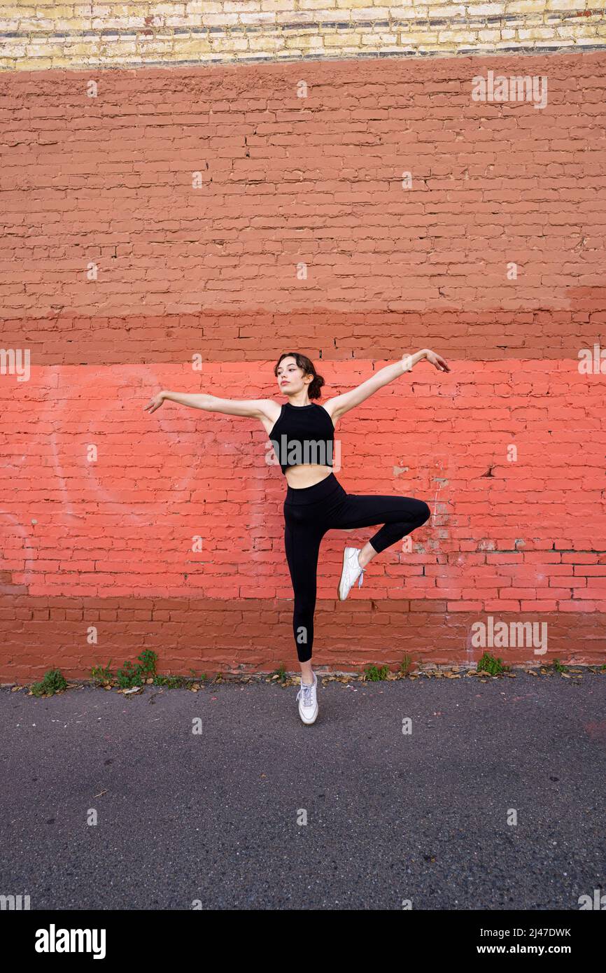 Teenage Female Dancer Standing by Painted Brick Building in Downtown ...