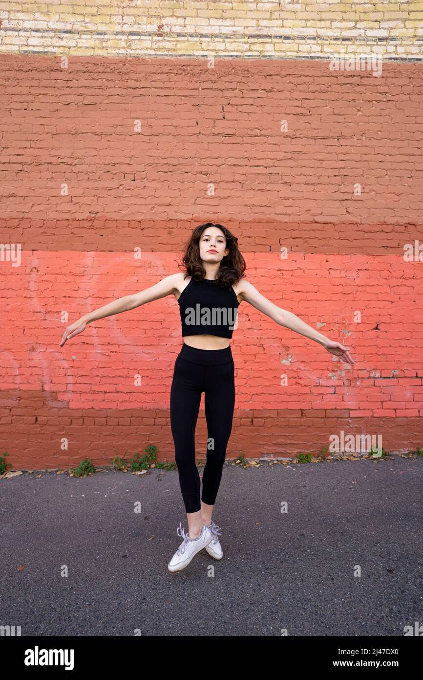 Teenage Female Dancer Standing by Painted Brick Building in Downtown ...