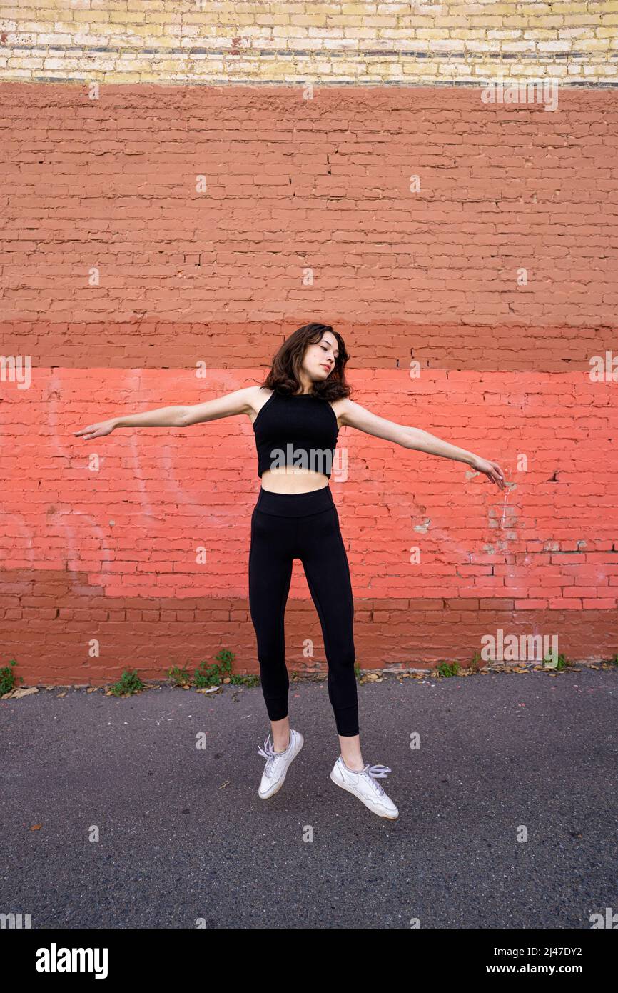 Teenage Female Dancer Standing by Painted Brick Building in Downtown ...