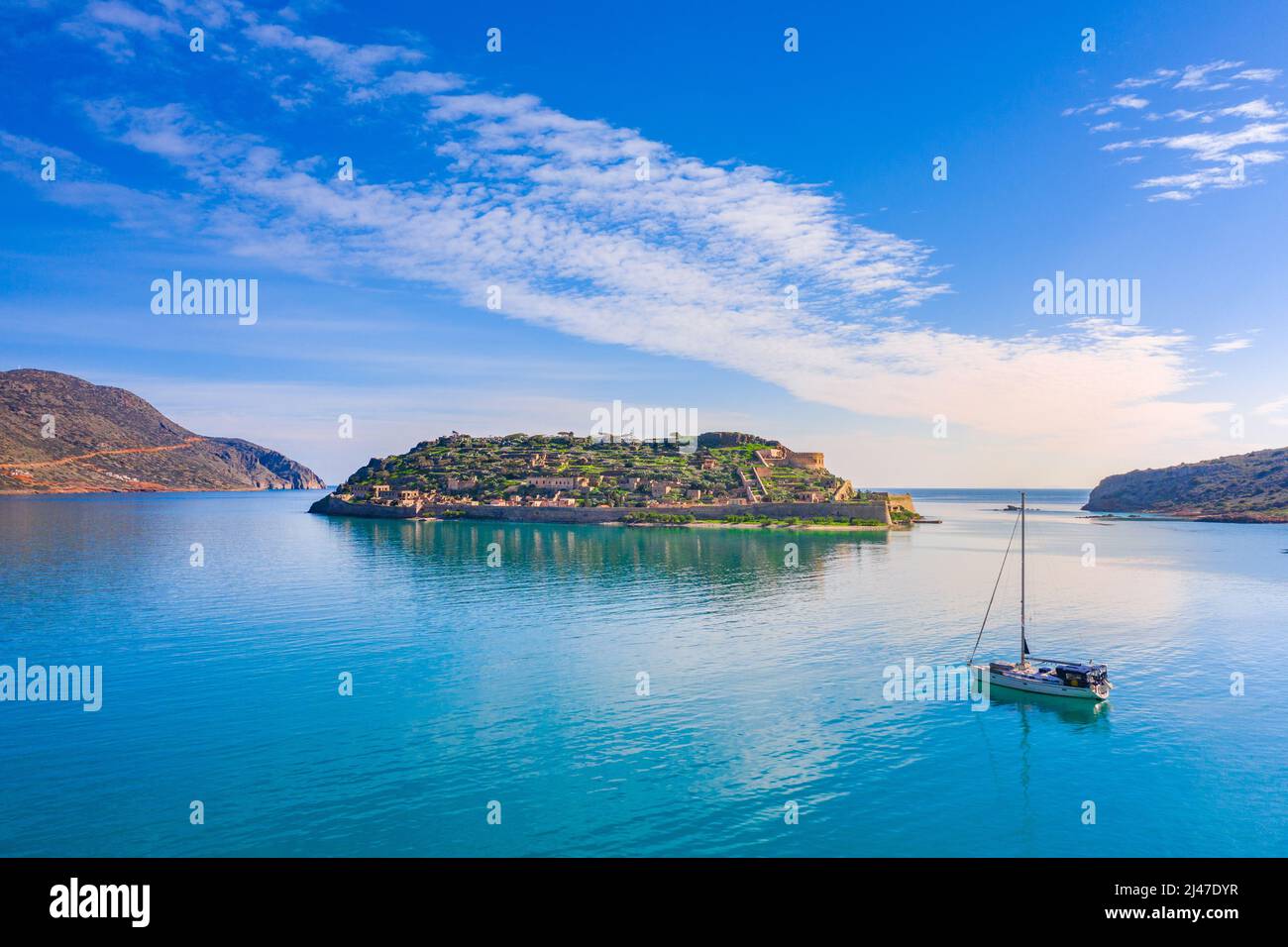 View of the island of Spinalonga with calm sea. Here were isolated ...