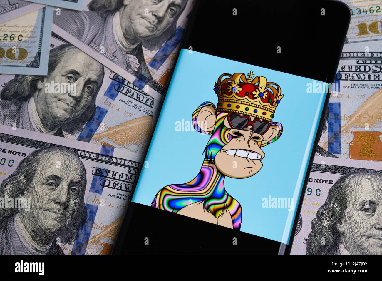 BORED APE 8585 NFT digital art seen on smartphone placed on plie of ...