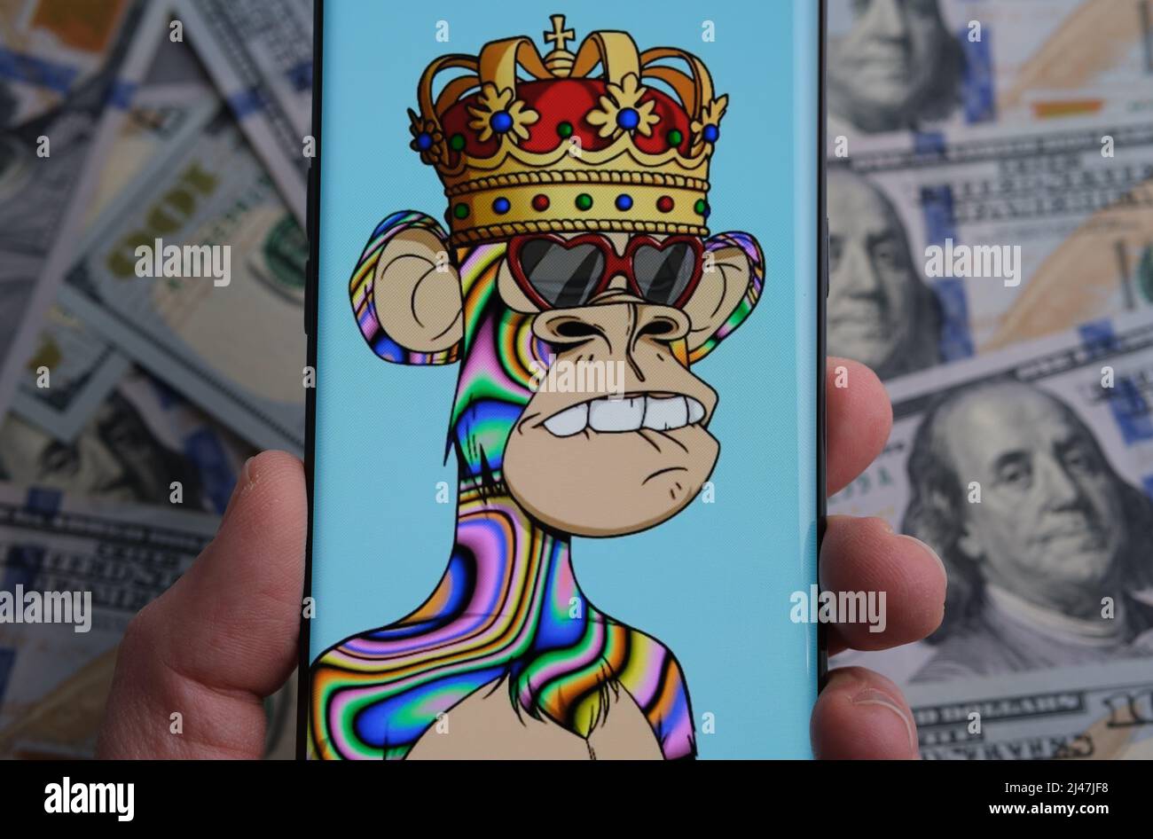BORED APE 8585 NFT digital art seen on smartphone placed on plie of ...