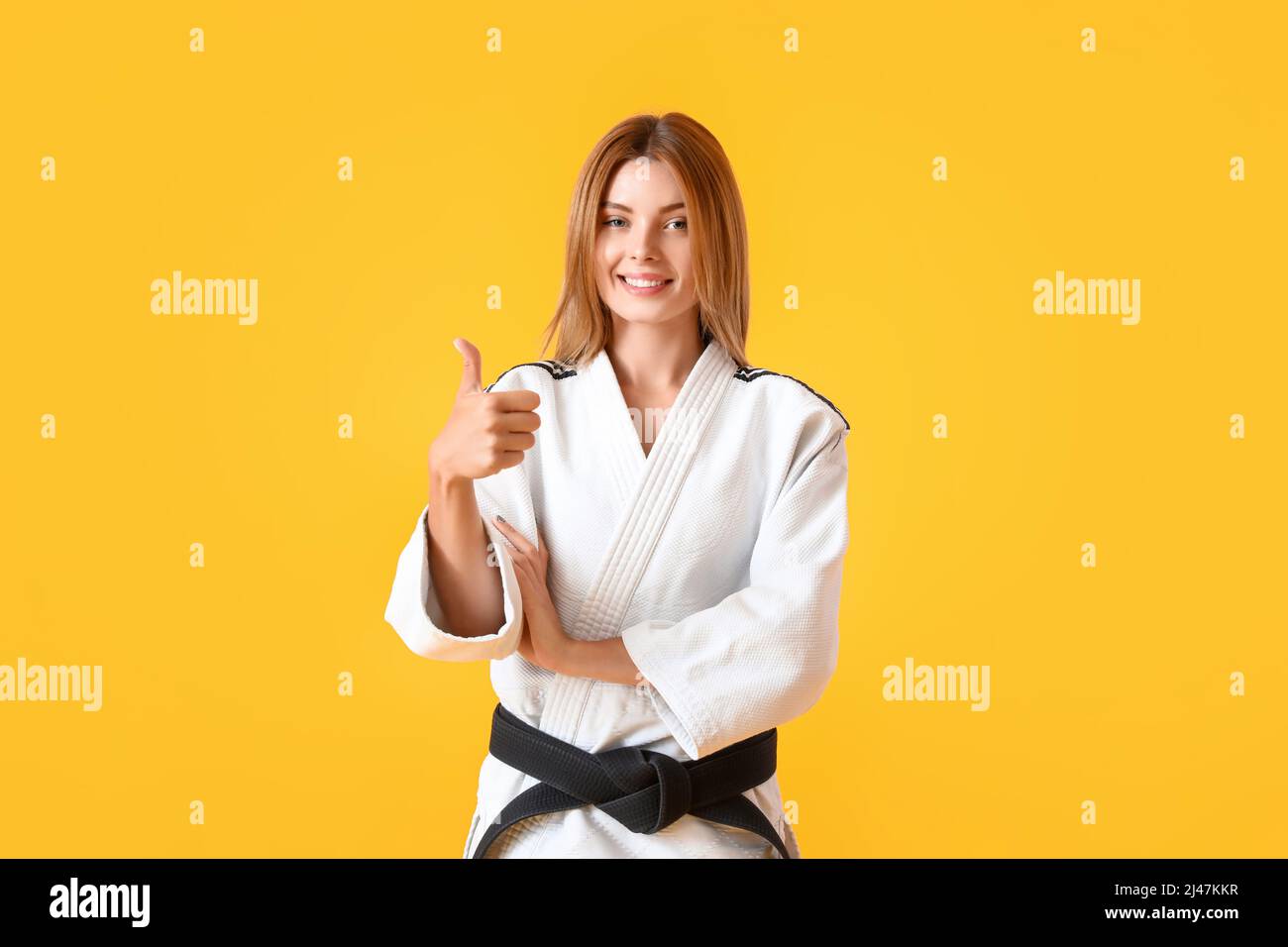 Female karate instructor showing thumb-up on color background Stock ...