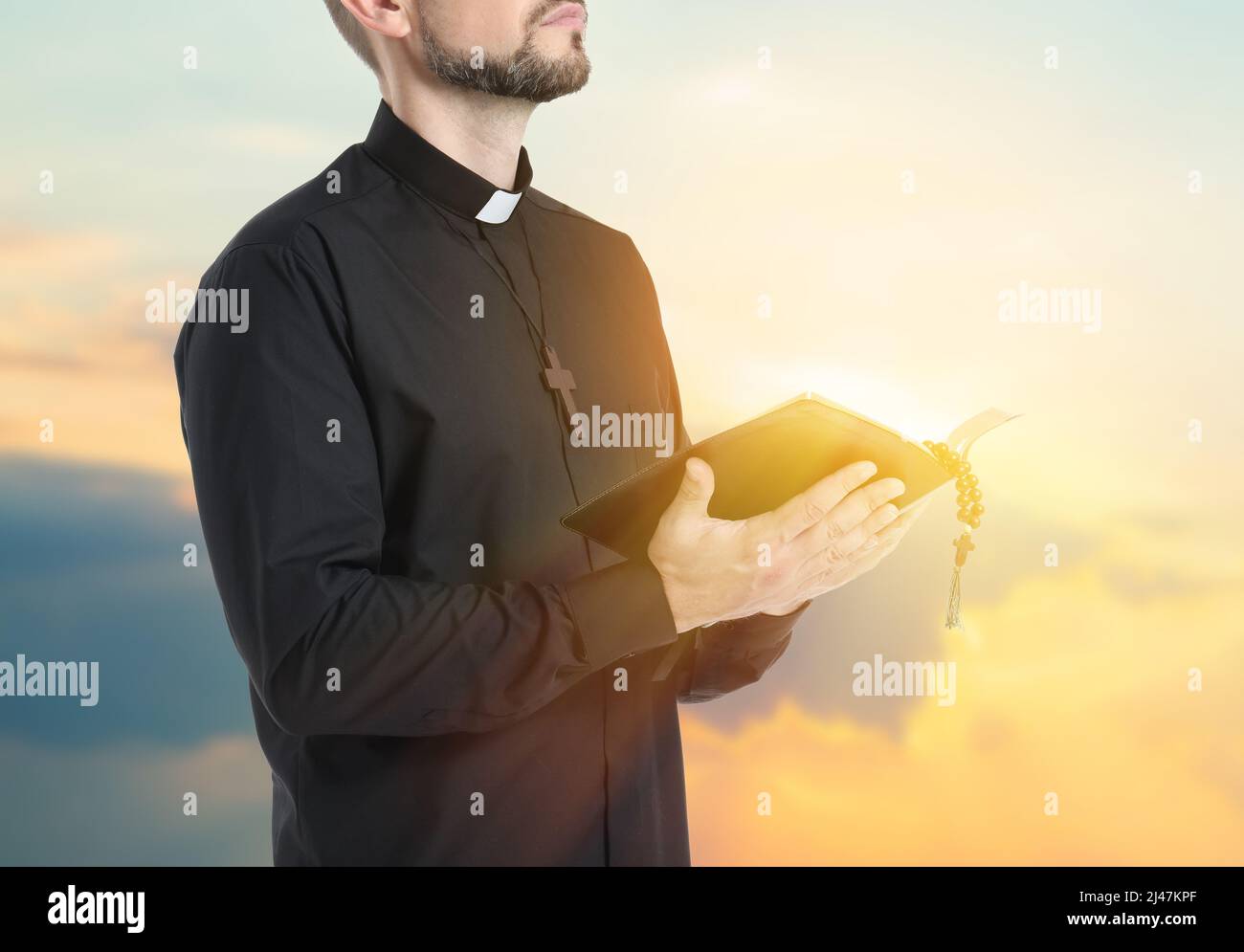 Priest with Holy Bible praying outdoors Stock Photo - Alamy