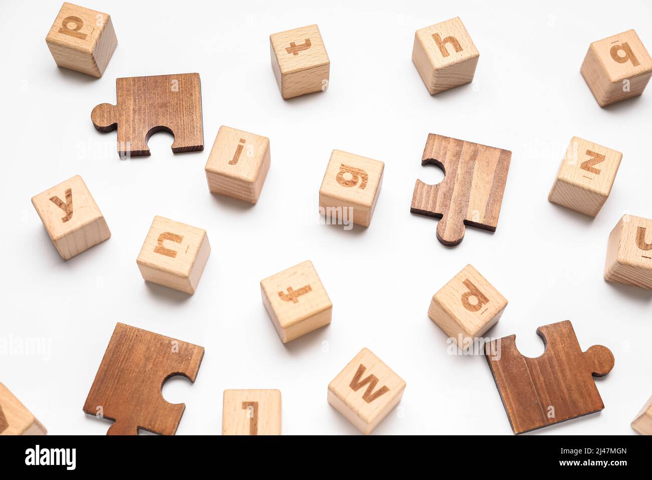 Wooden cubes with letters and puzzle pieces on white background Stock ...