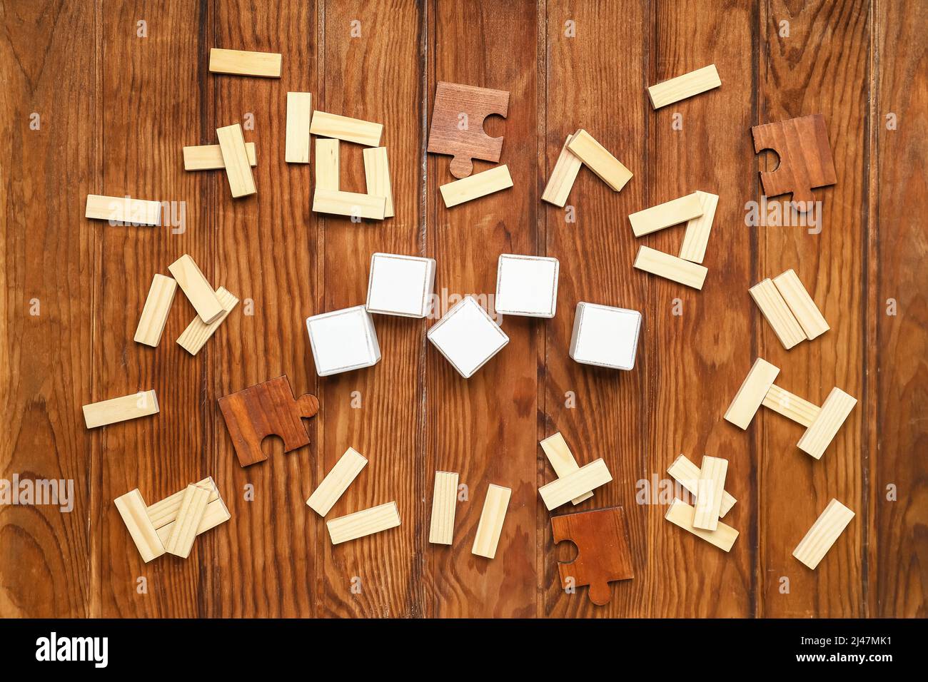 Cubes with blocks and puzzle pieces on wooden background Stock Photo ...