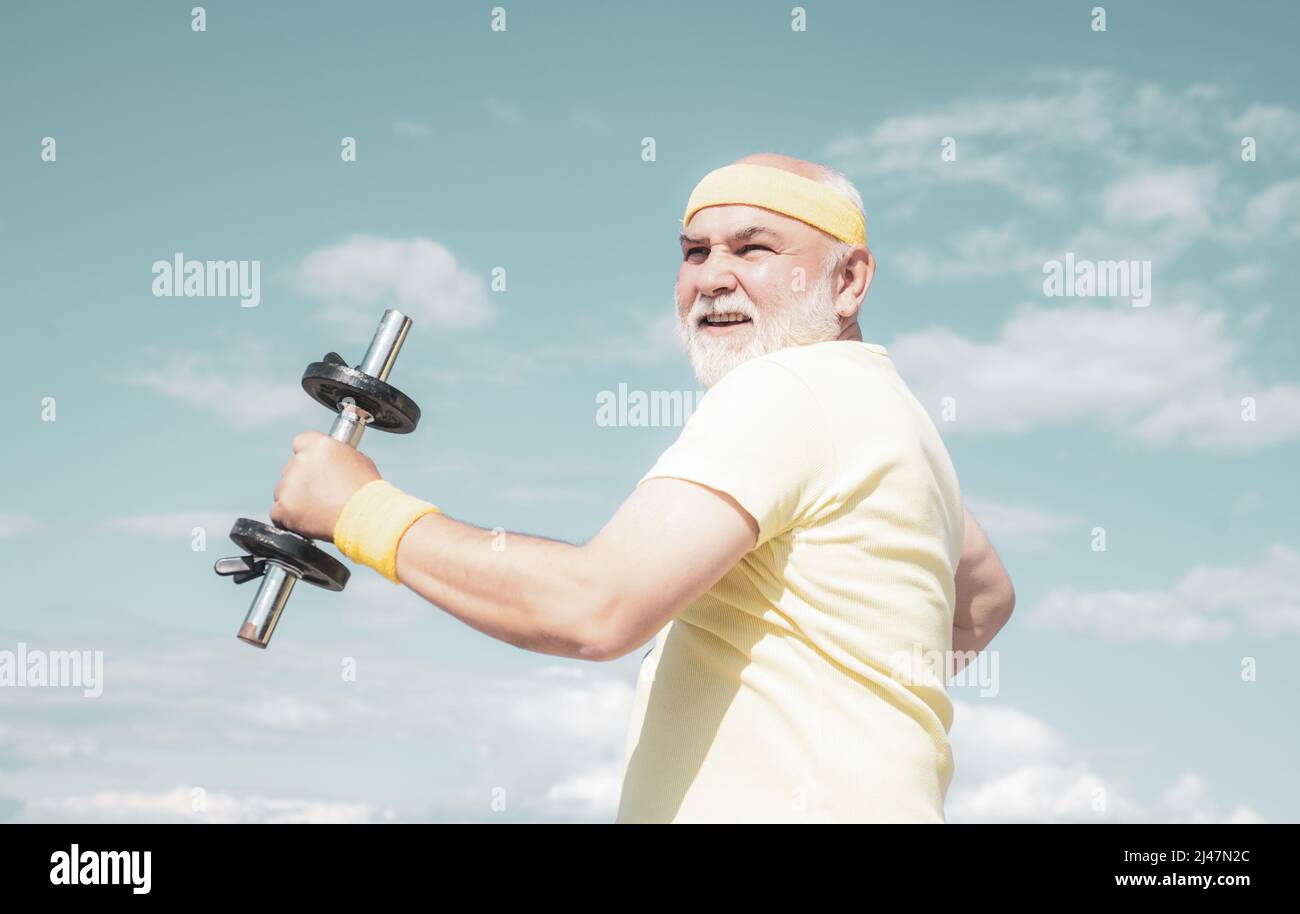 Old mature man exercising with dumbbell. Senior sportsman in sport ...