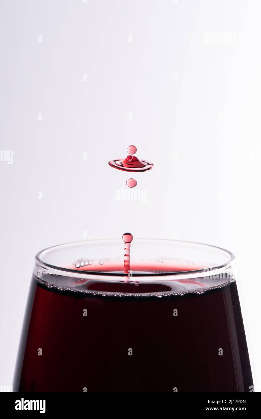 Droplet of red wine falling in a glass isolated on white close up Stock ...