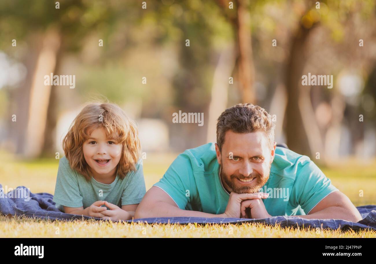 Happy father and son enjoying summer time on vacation in a sunny park ...