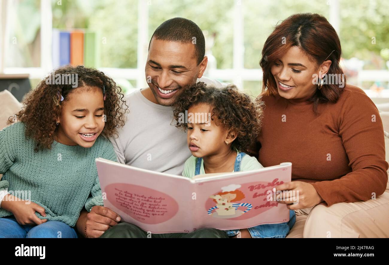 These pages tell a magical story. Shot of a young family reading a book ...