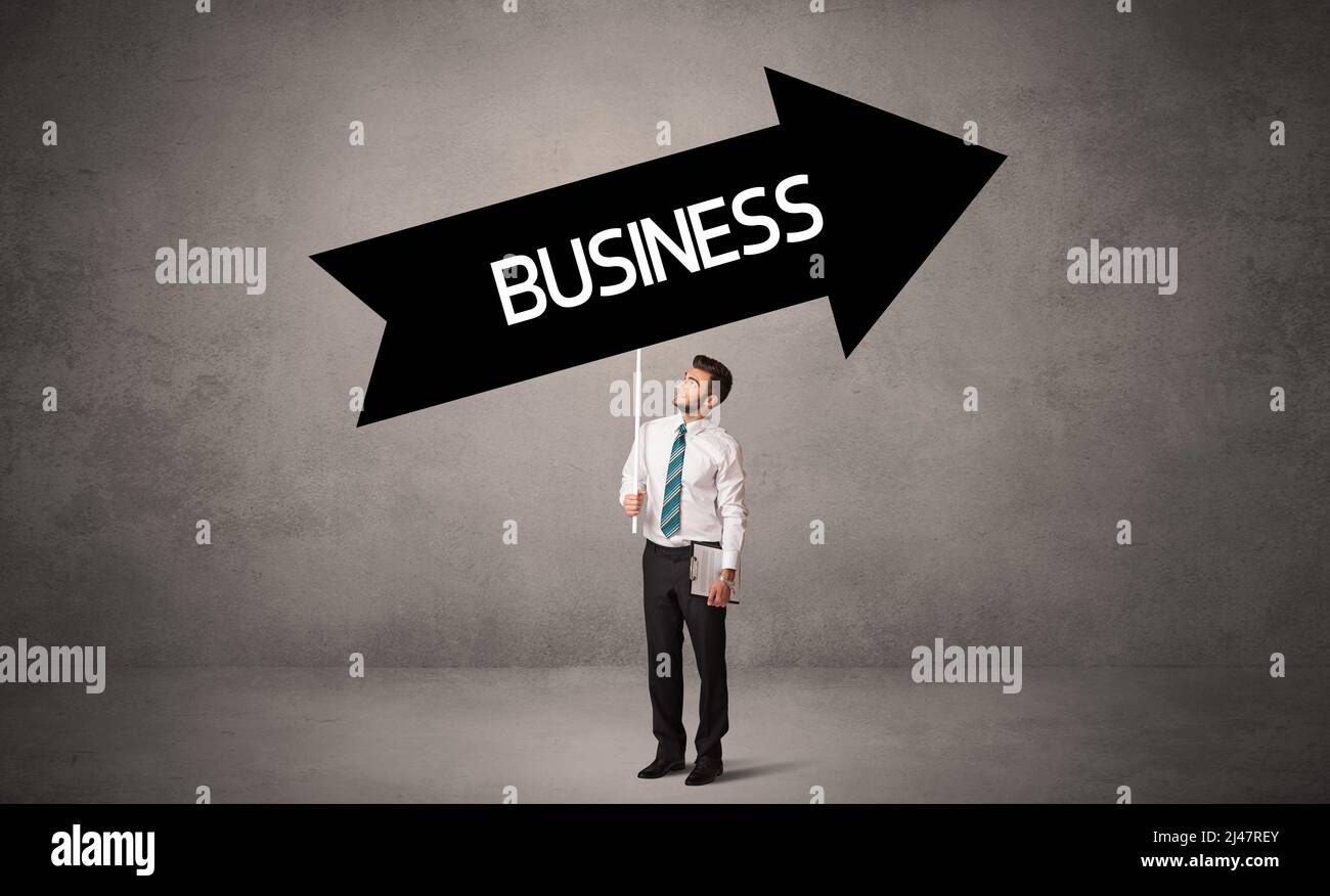 Young business person in casual holding road sign Stock Photo - Alamy