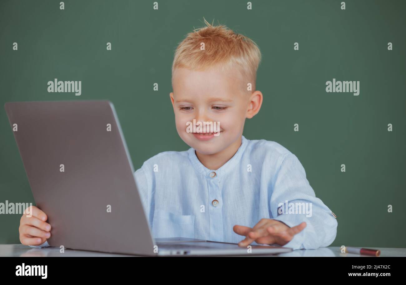 Cute smiling child using laptop computer, kid boy studying through ...