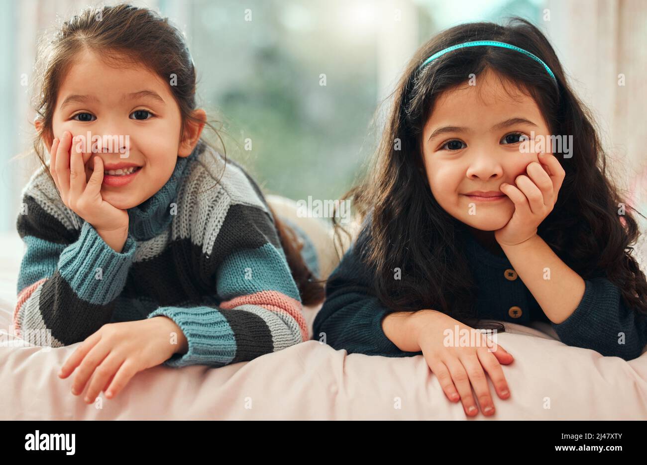 Just chilling with my sister. Shot of two little sisters relaxing at ...