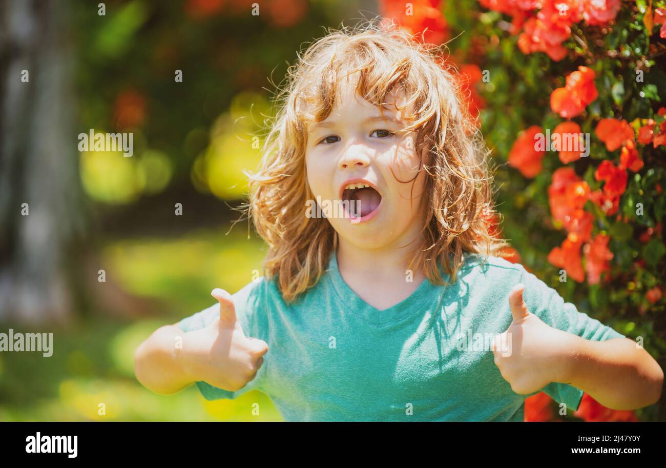 Close up portrait of a cute little child thumbs up sign. Kids enjoying ...