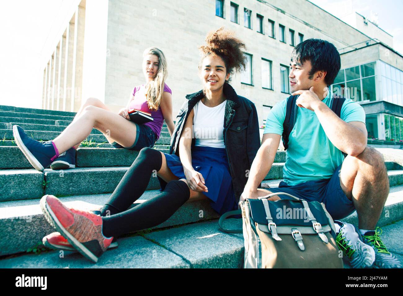 cute group of teenages at the building of university with books ...