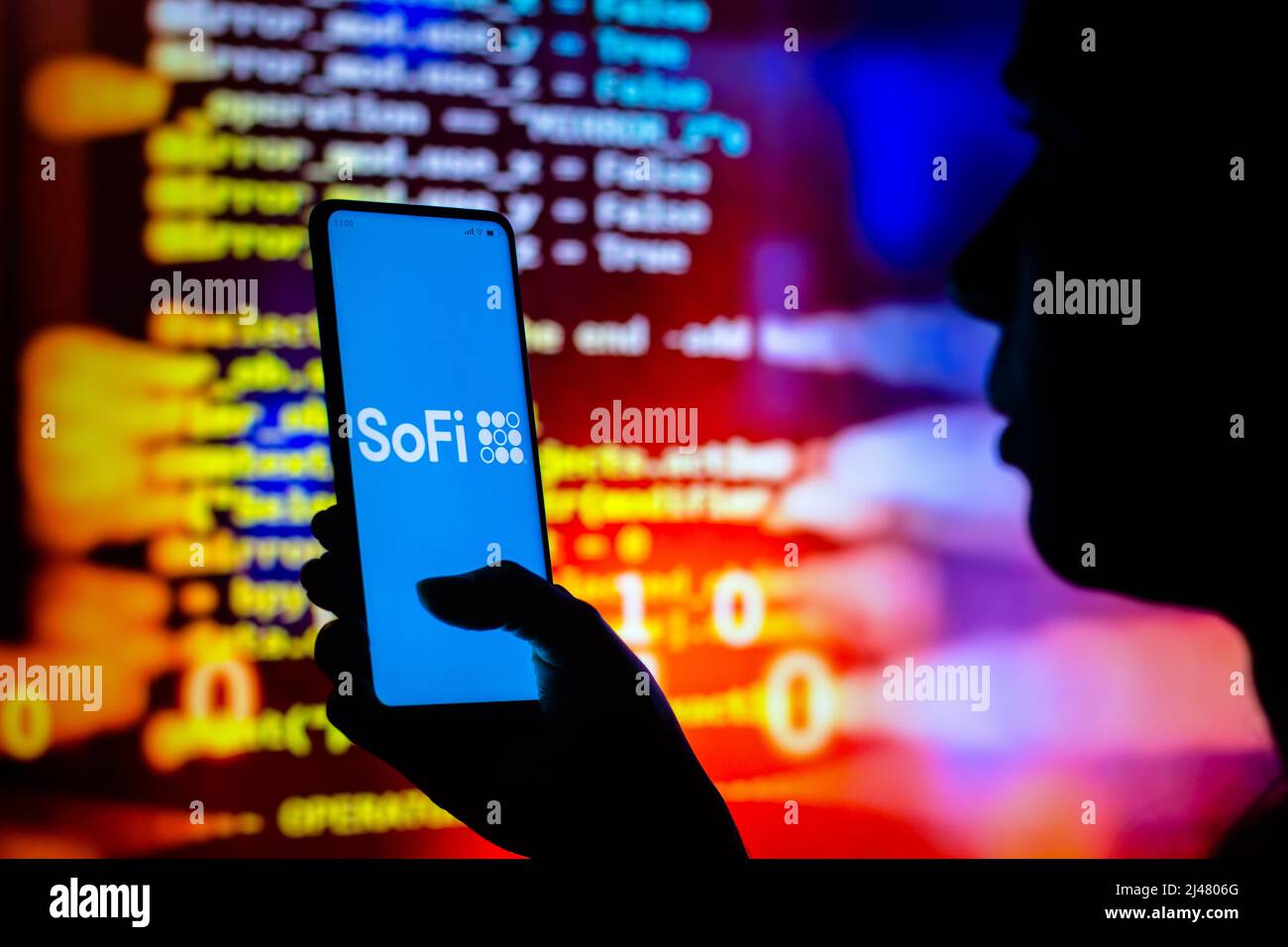 In this photo illustration, a woman holds a smartphone with the SoFi ...