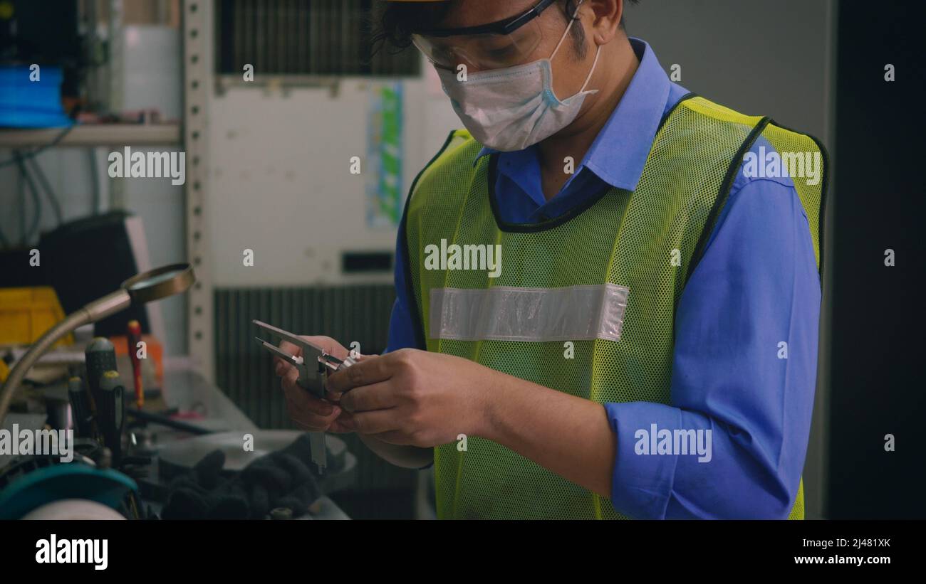 Asian factory worker technician man operating measuring steel size of ...