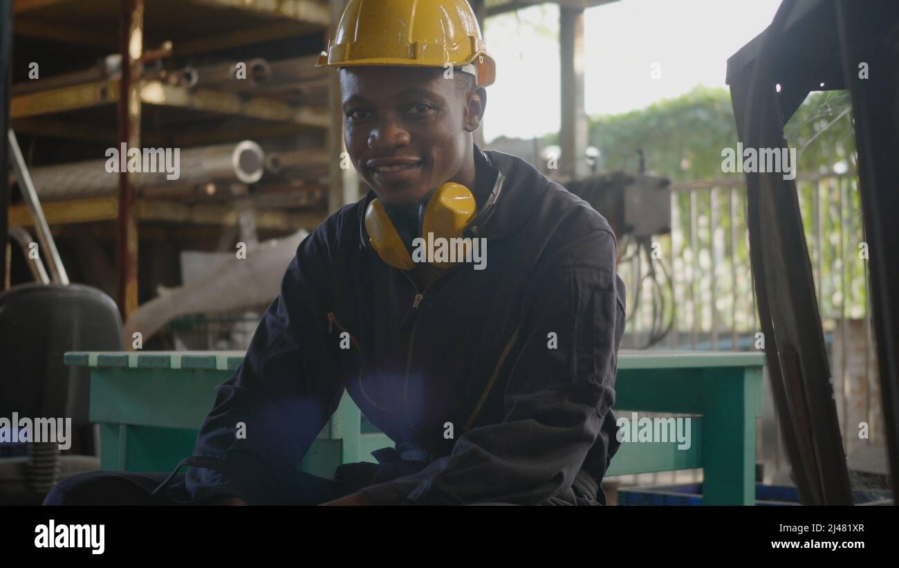 Portrait American industrial black young worker man smiling with yellow ...