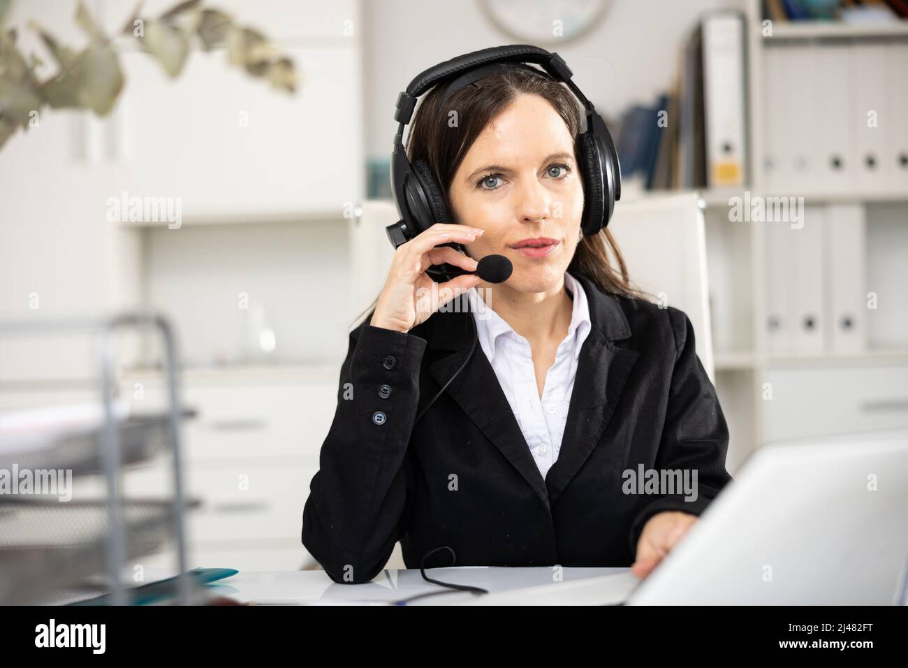 Portrait of female call center worker with headphones Stock Photo - Alamy
