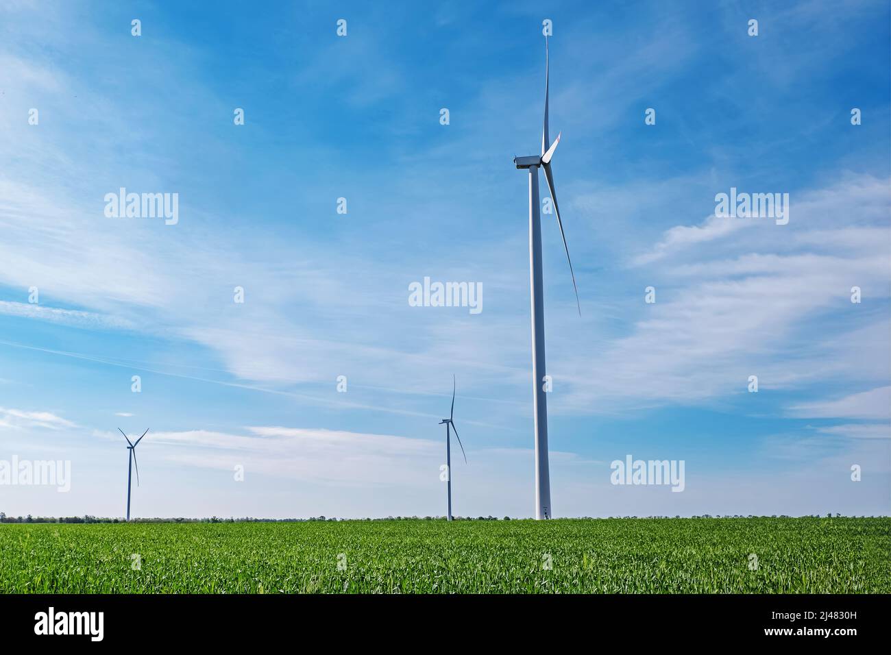Electrical wind power mills over the blue sky. Alternative energy ...