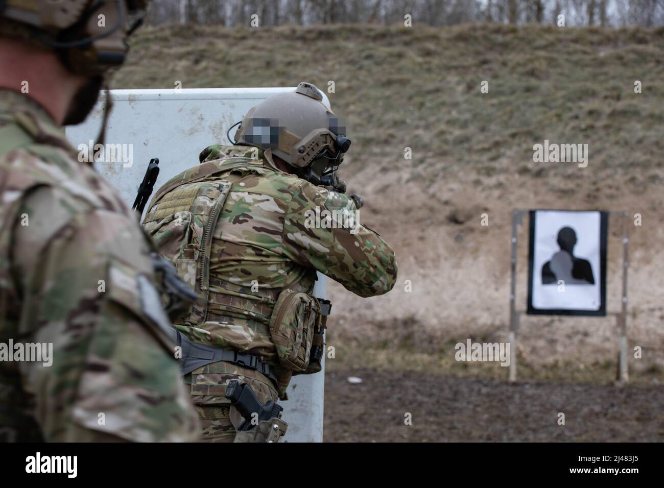 A U.S. Special Forces member sights his target using a barrier for ...