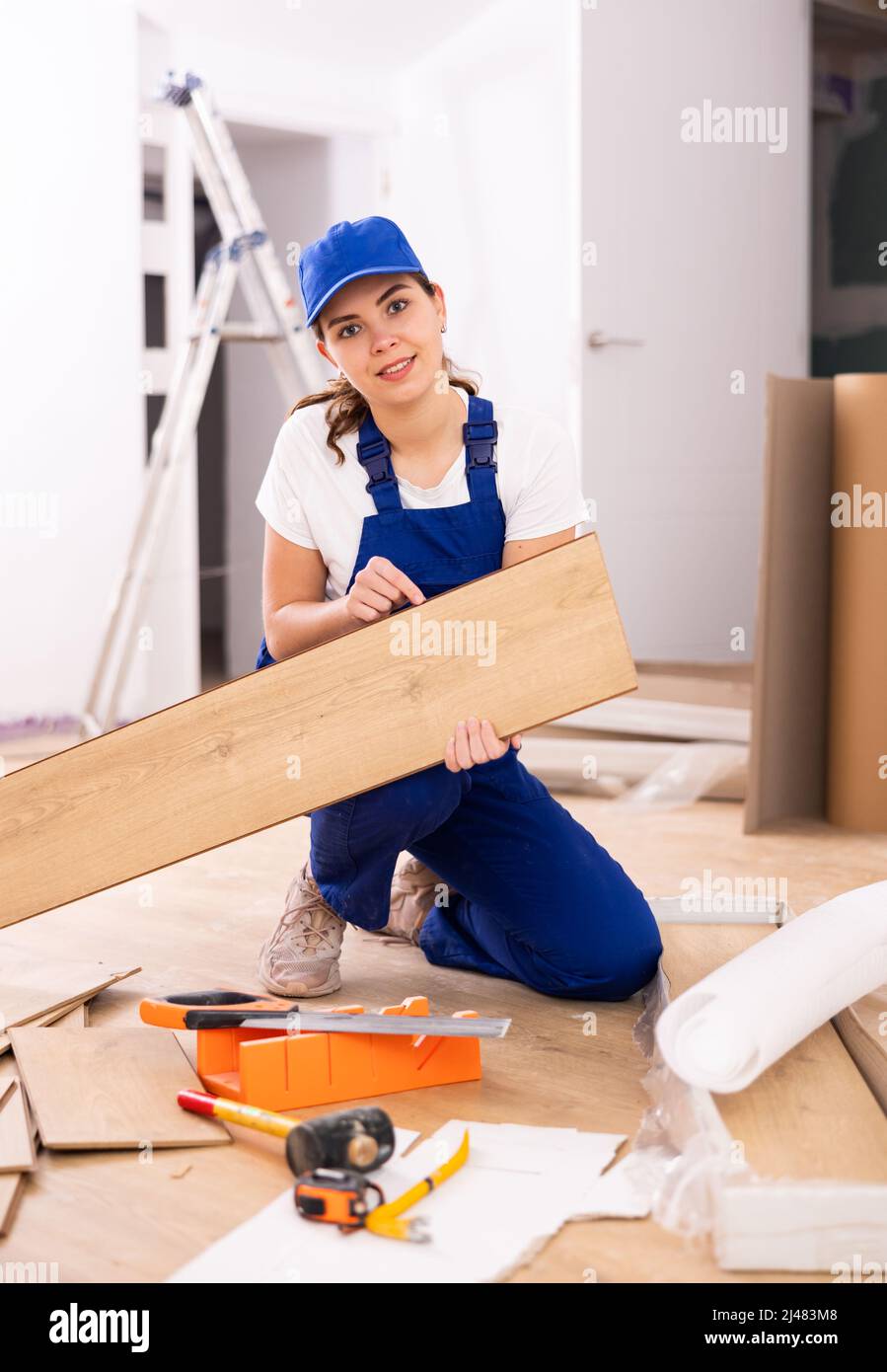 Female builder checking laminate planks before installation Stock Photo ...
