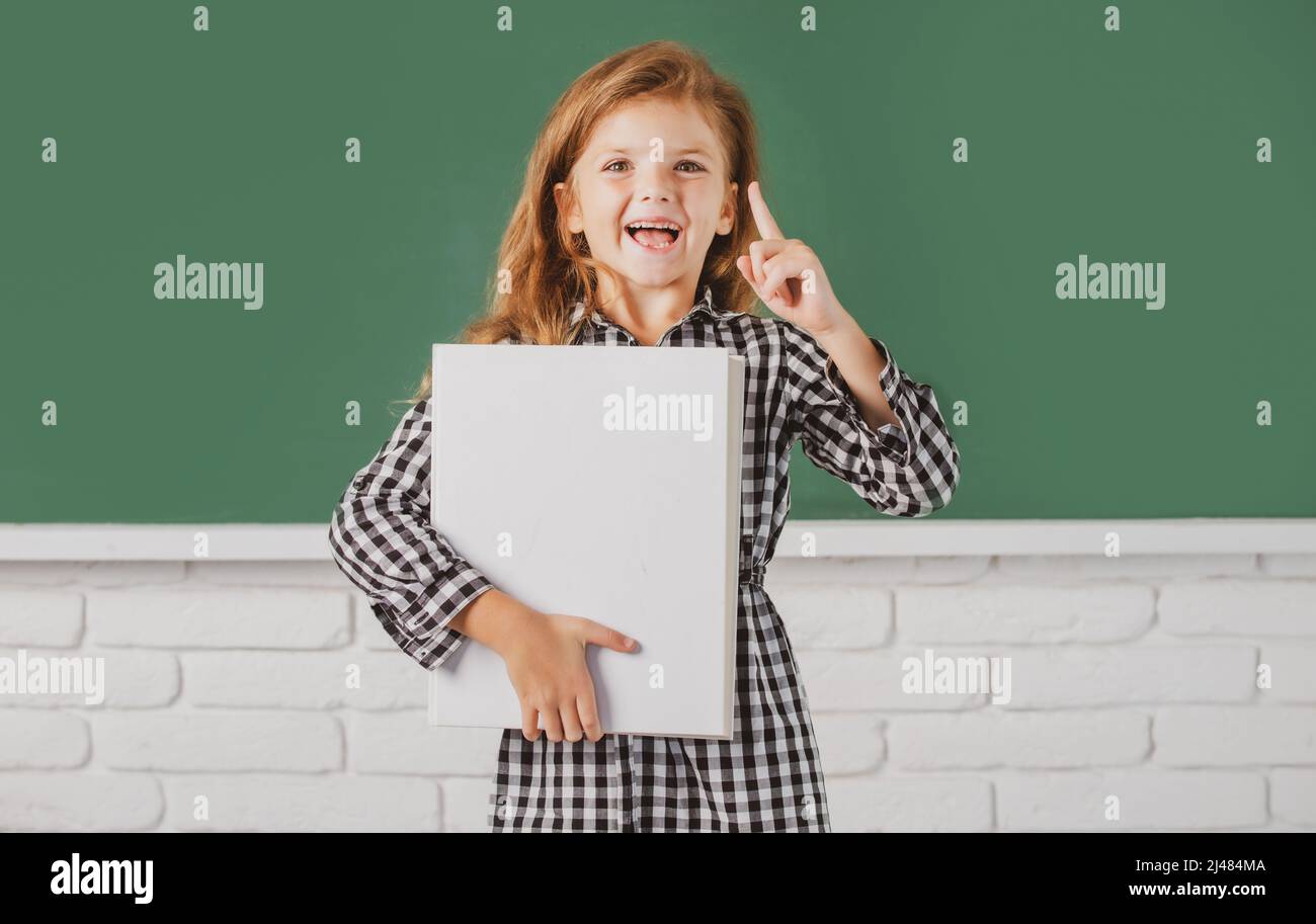 Cute child at school. Kid is learning in class on background of ...