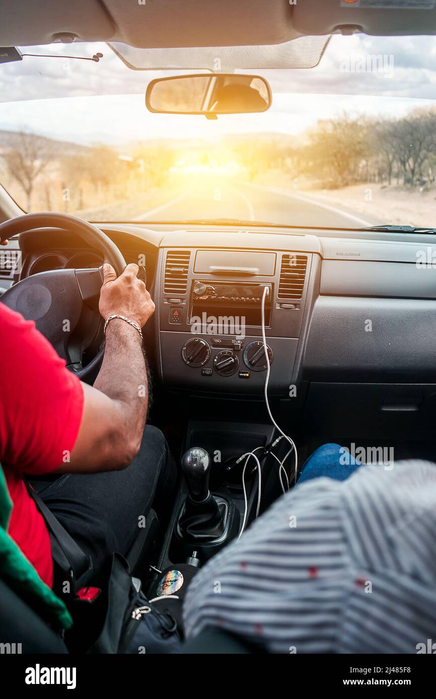 Vertical photo of an unrecognizable black man driving his car on a ...