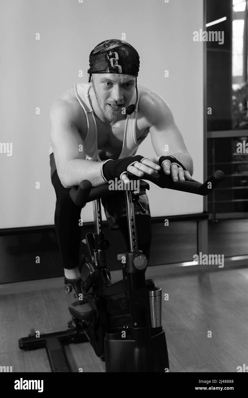 Young man training on exercise bike Black and White Stock Photos ...