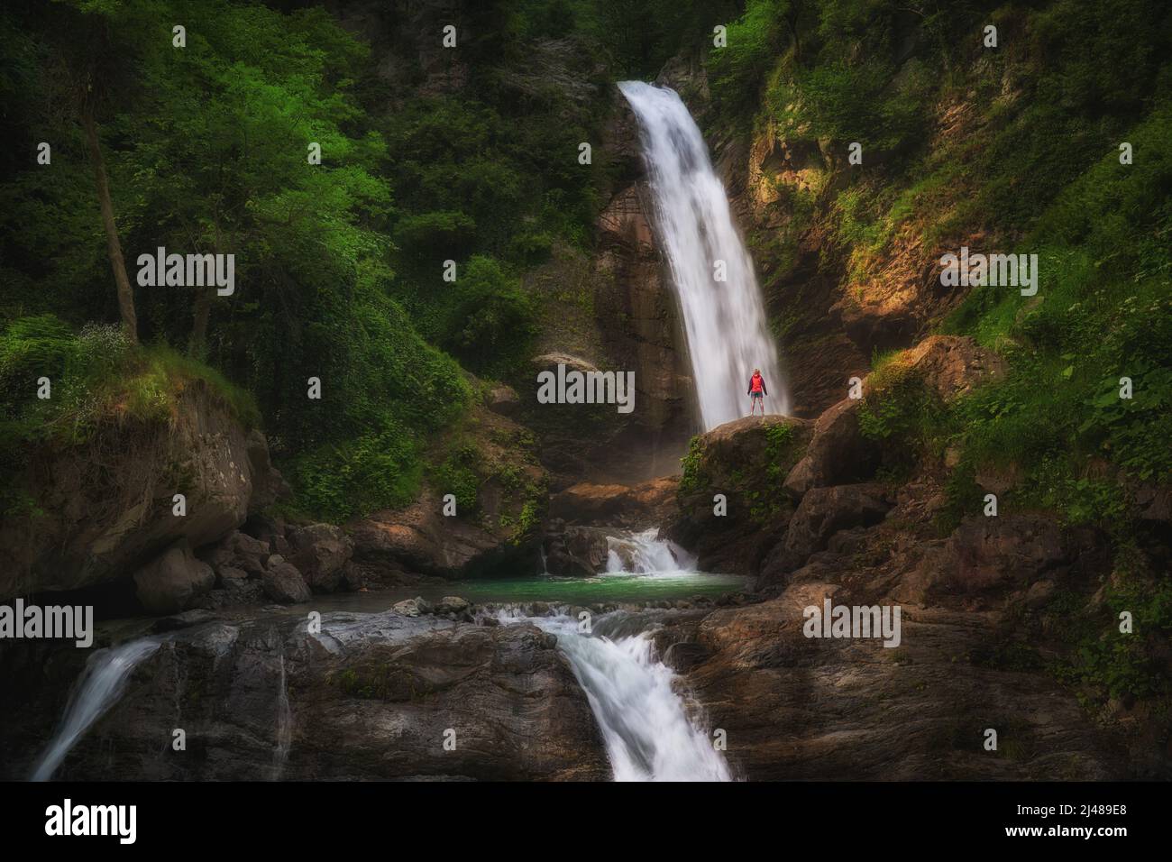 Hiking woman in red jacket stay at big waterfall in mountains Stock ...