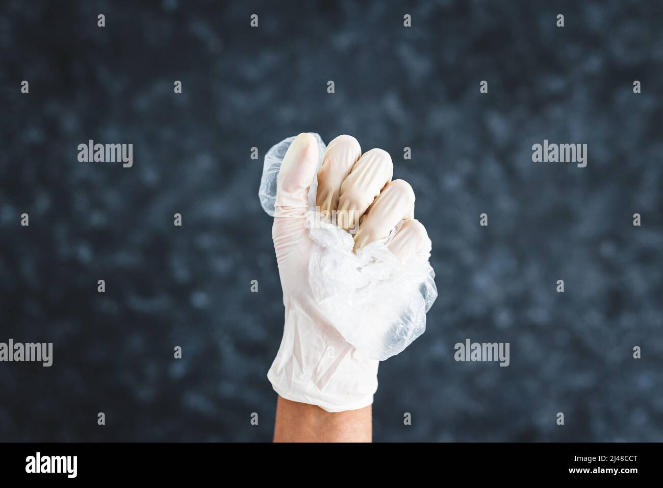 hand with glove picking up single-use plastic bag to be recycled ...
