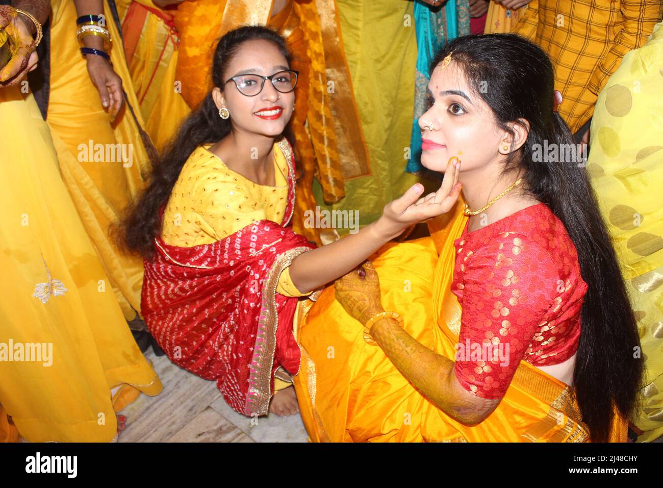 Indian Hindu bride with turmeric paste applied on her face having fun ...