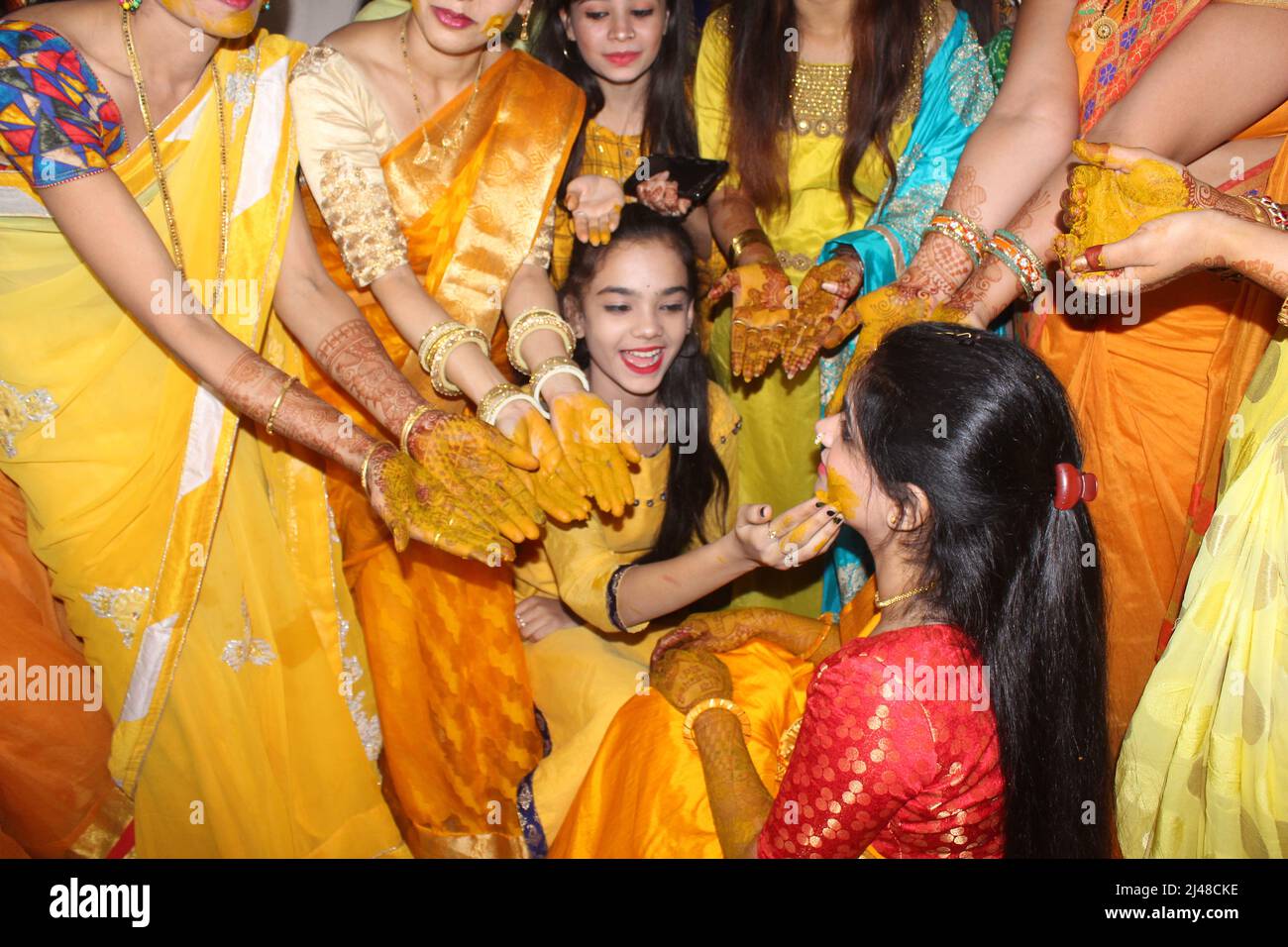 Indian Hindu bride with turmeric paste applied on her face having fun ...