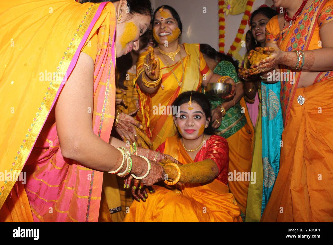 Indian Hindu bride with turmeric paste applied on her face having fun ...