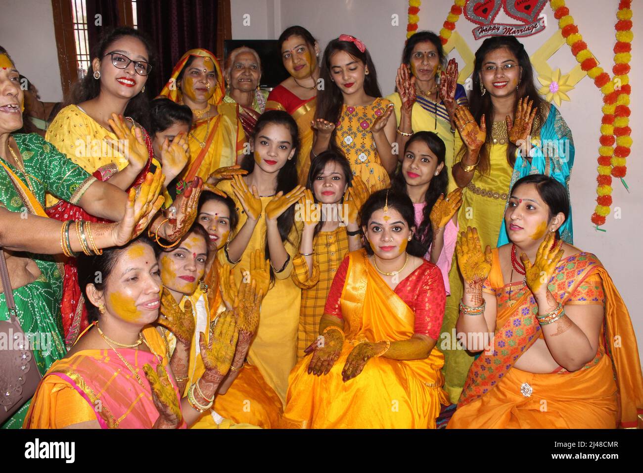 Indian Hindu bride with turmeric paste applied on her face having fun ...