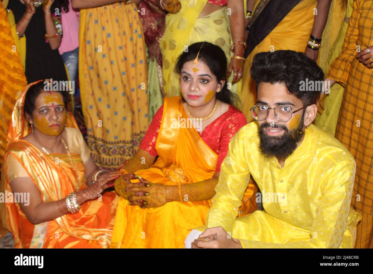 Indian Hindu bride with turmeric paste applied on her face having fun ...