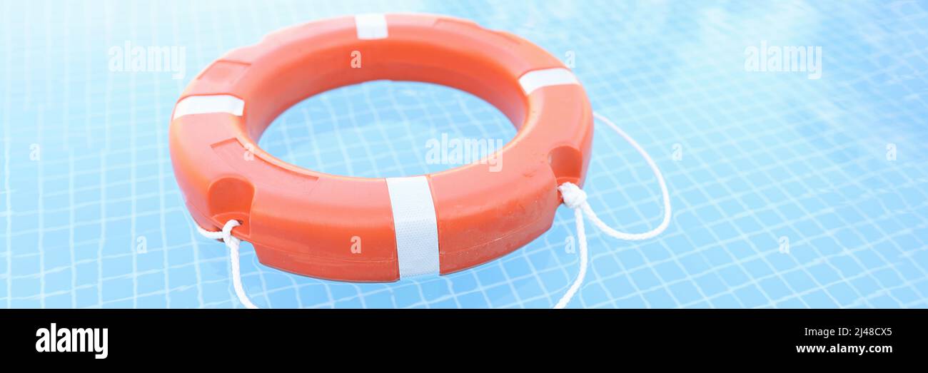 Orange plastic lifebuoy floating in pool closeup Stock Photo - Alamy