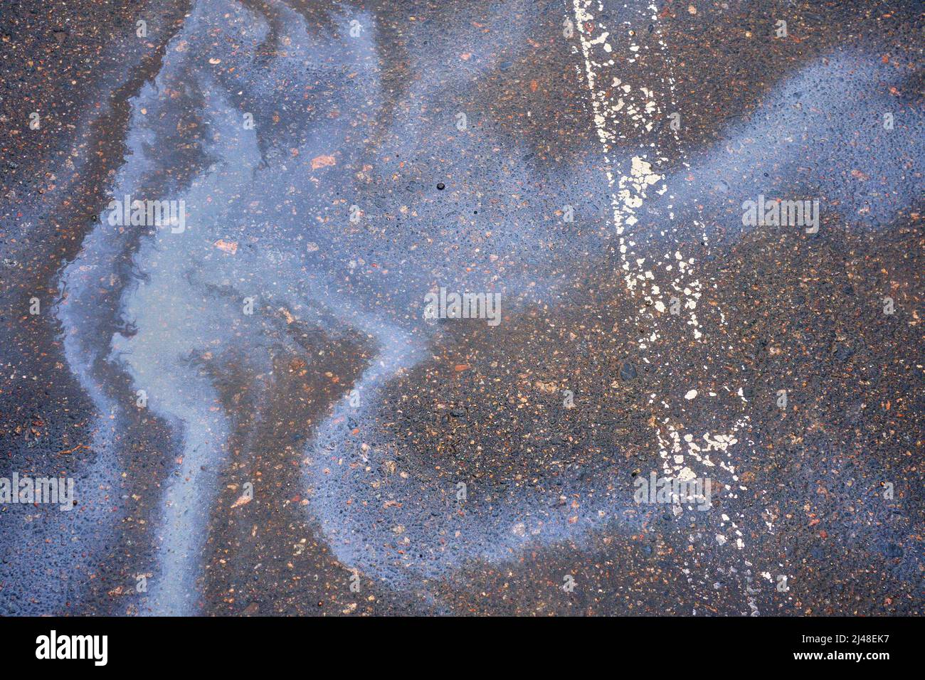 Gasoline spill on asphalt in a car park as a texture or background ...