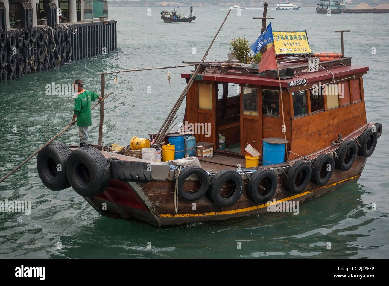A small traditional junk is used to remove floating garbage from ...