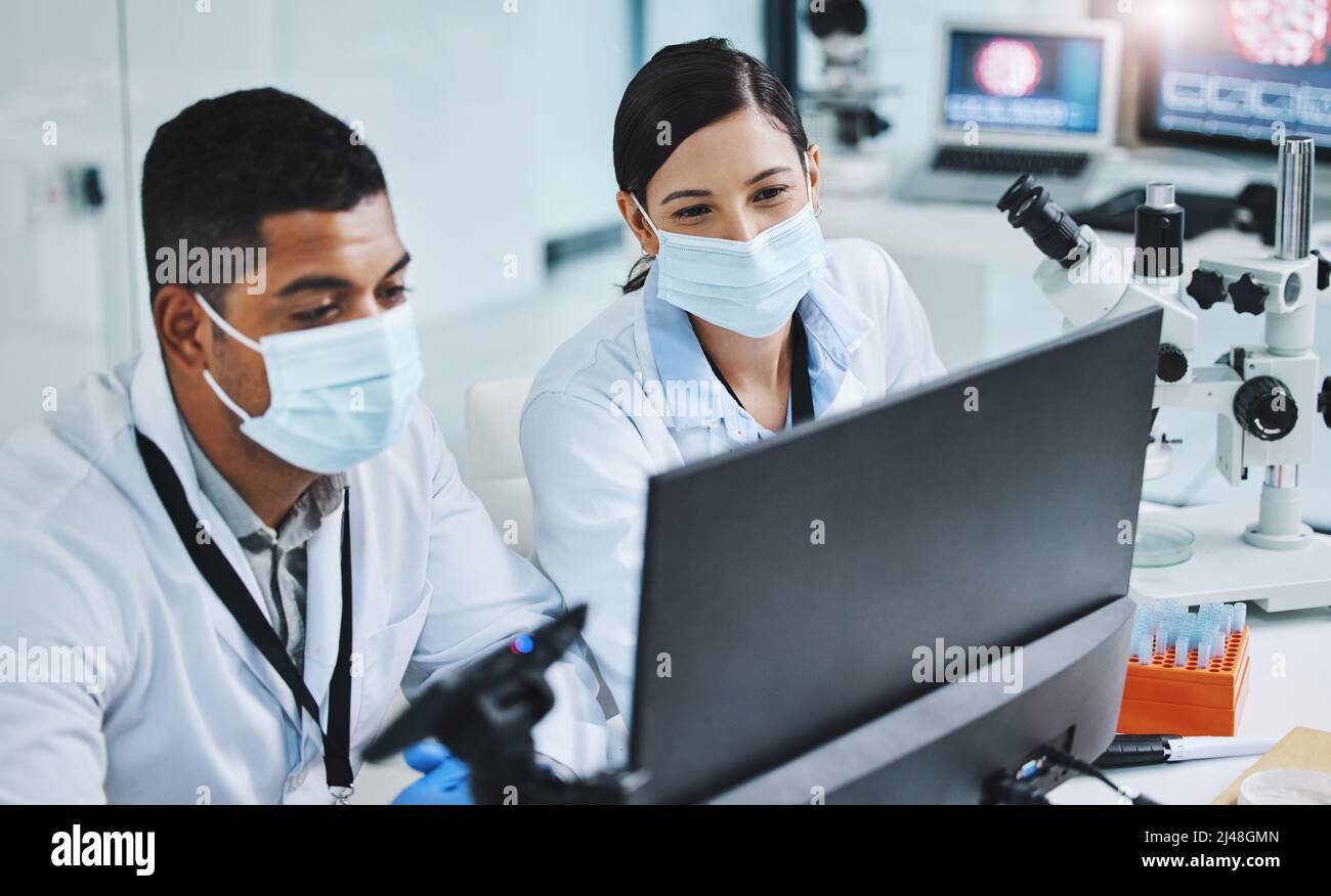 Everyday we get closer to our goal. Shot of two young researchers using ...