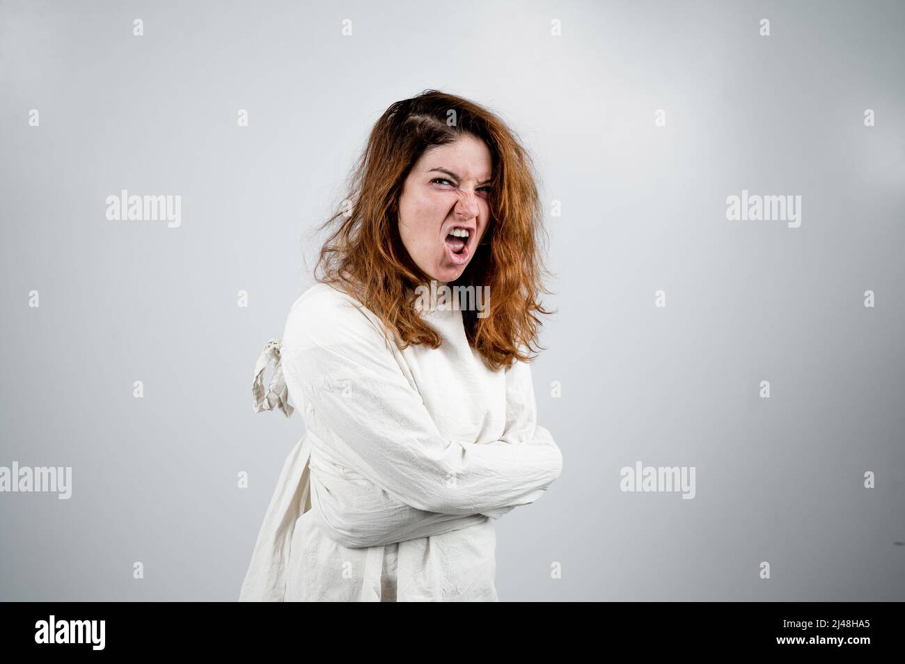 Close-up portrait of insane woman in straitjacket on white background ...