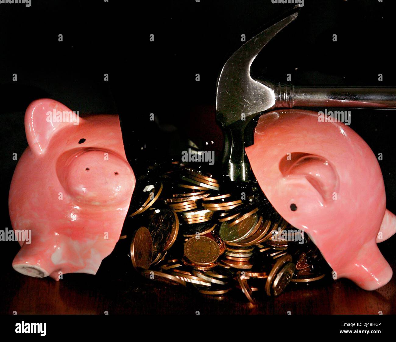 A traditional piggy bank smashed open with a hammer hi-res stock ...