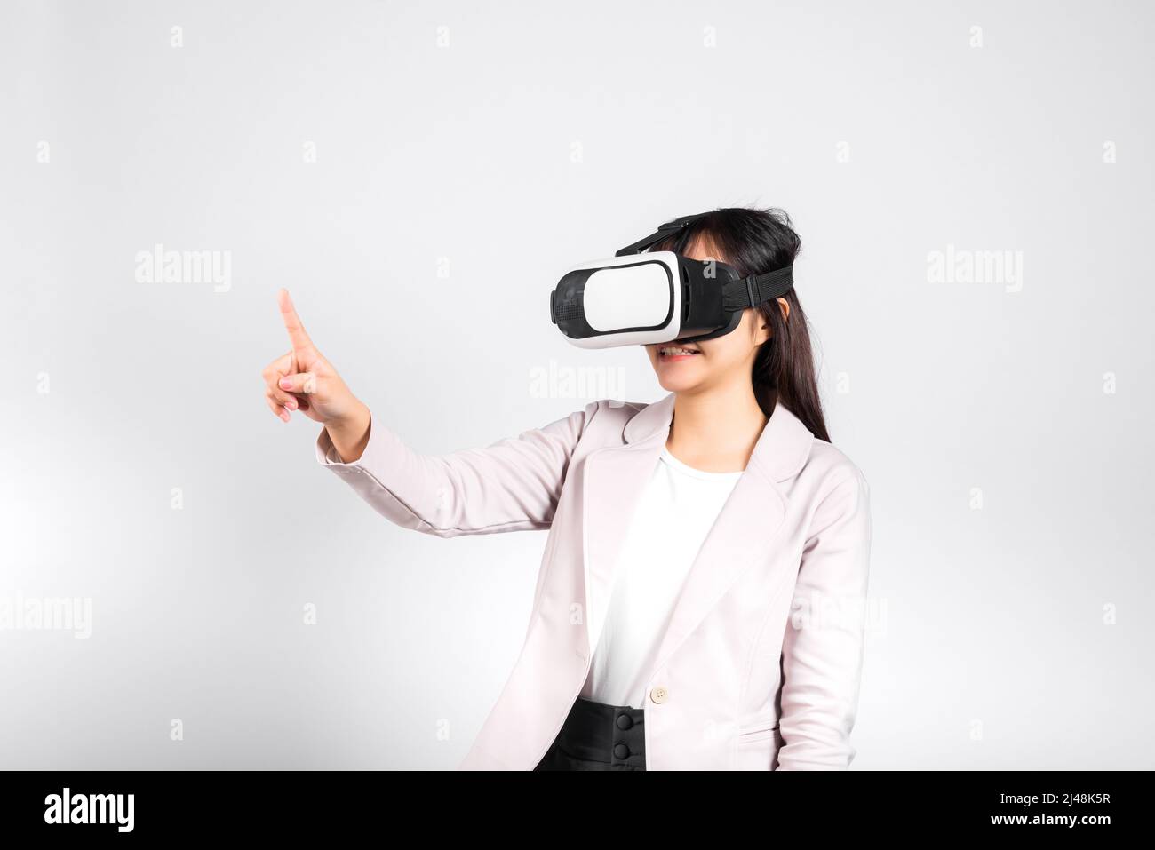 Smiling woman confidence wearing VR headset device touching air during ...