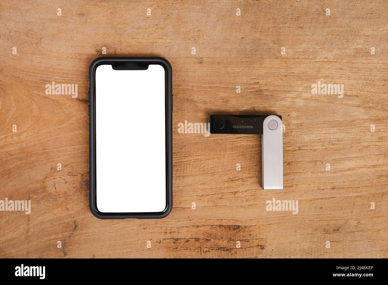 Mobile phone and Hardware wallet on wooden table background Stock Photo ...