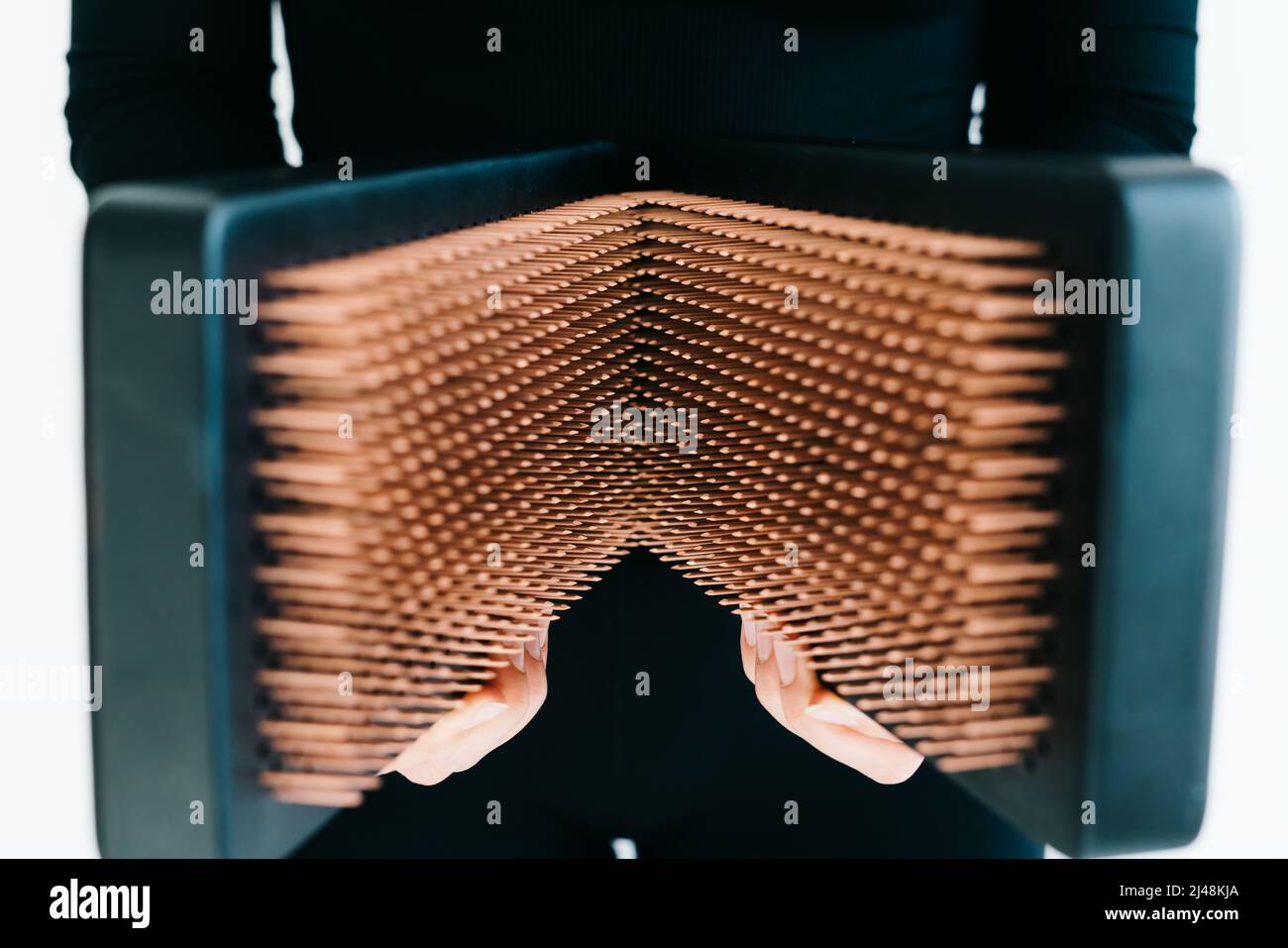 a sadhu board made of dark oak with copper nails on a wooden floor. the ...