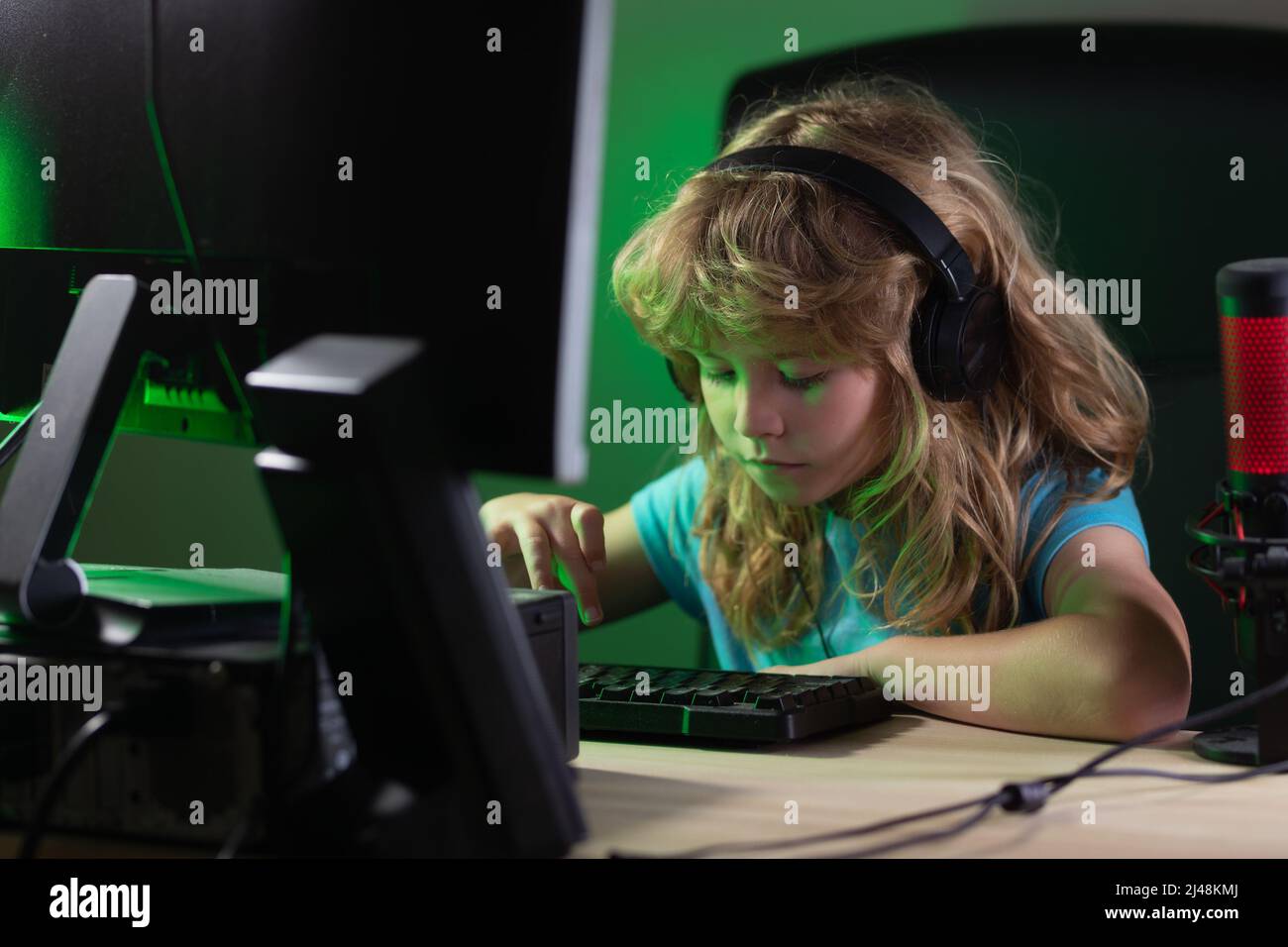 Child plays a video game on the pc computer screen. Gamer play computer ...