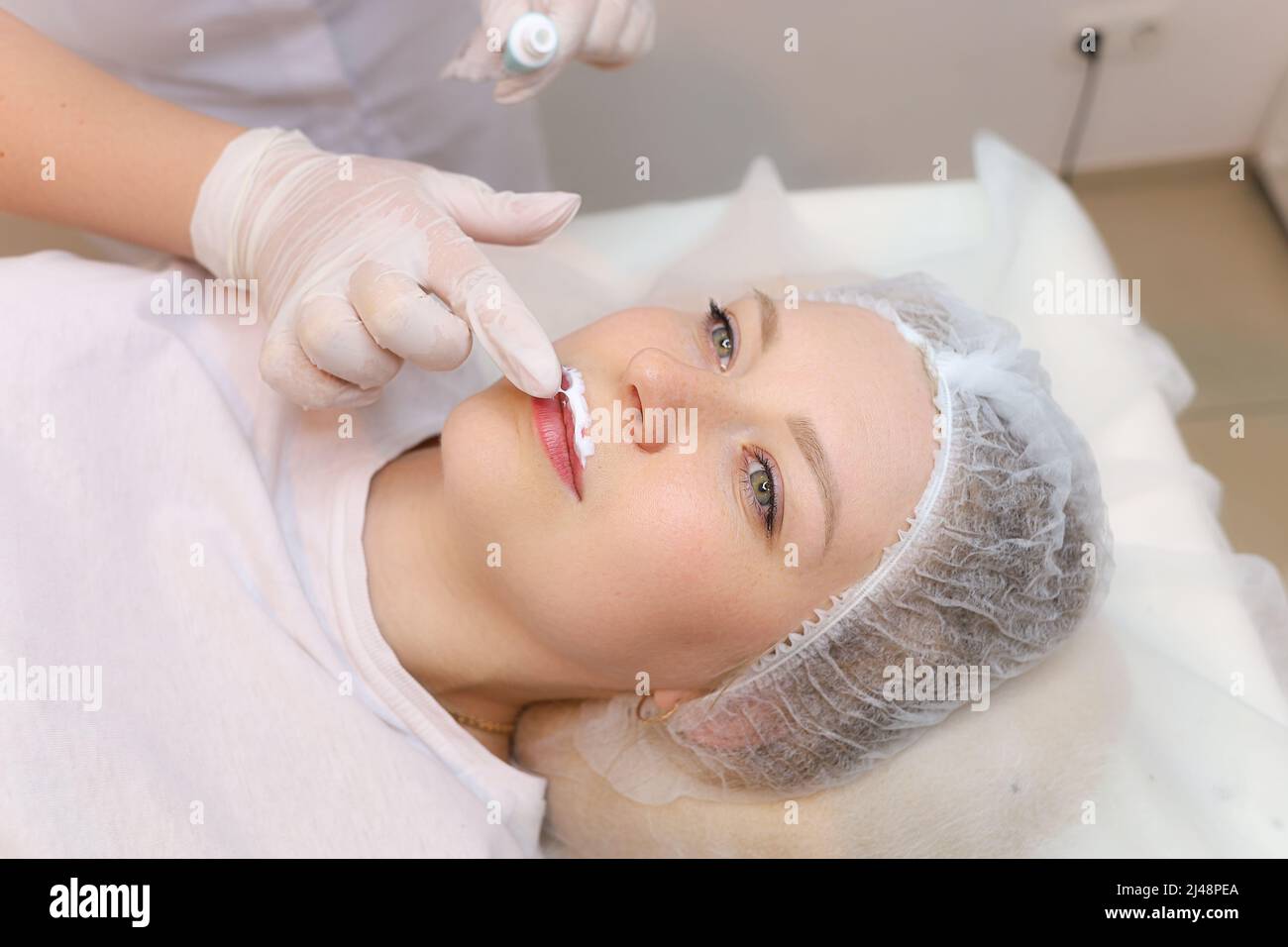The cosmetologist applies anesthesia prepares the client's lips for the ...