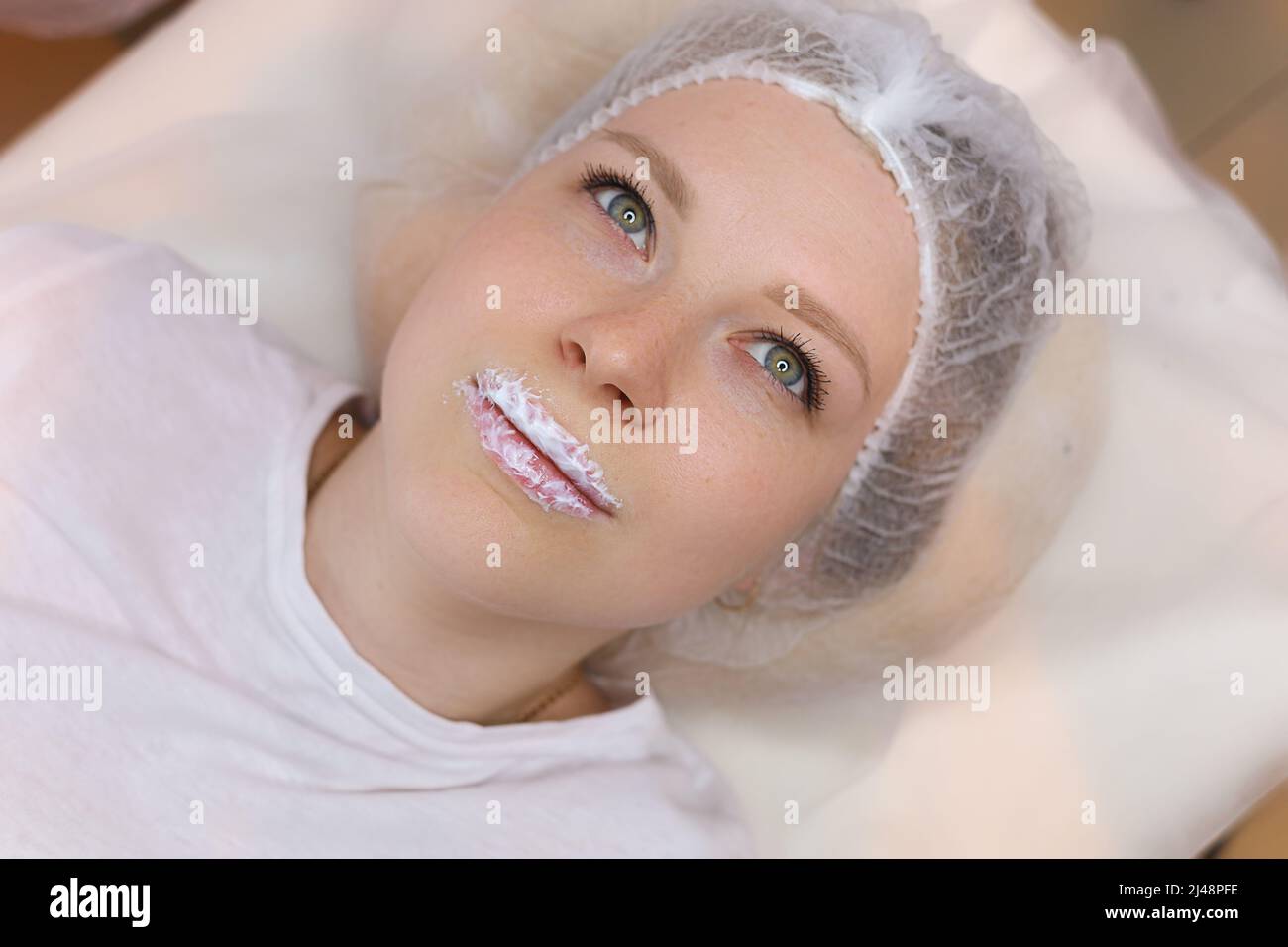 The girl is lying on the couch at the cosmetologist with anesthesia ...