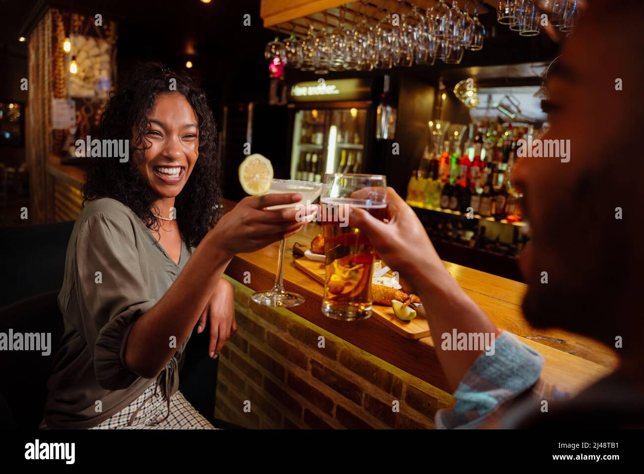two friends having drinks at the bar cheers Stock Photo - Alamy