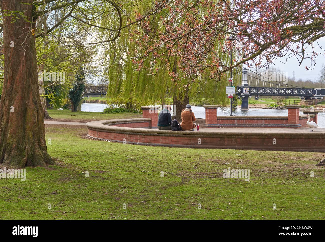 Two close women friends sitting together in a park by a river Stock ...